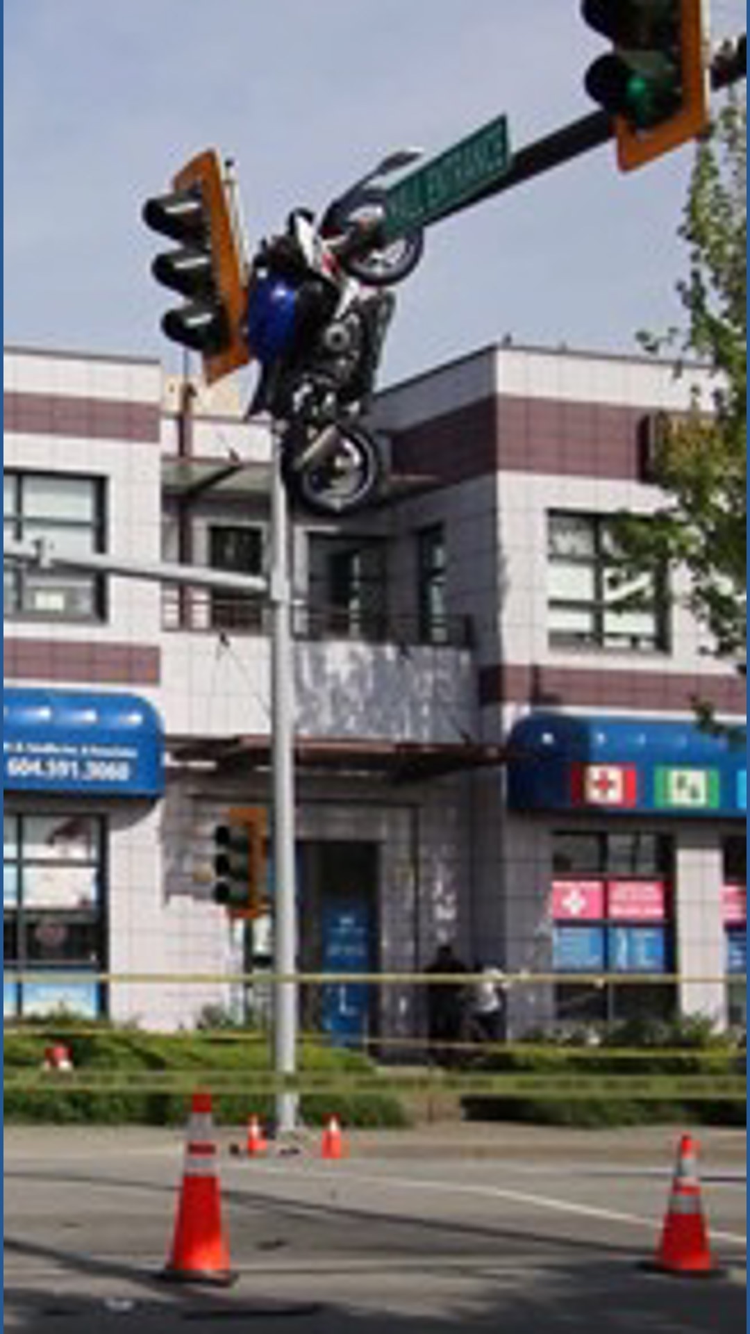 Motorcycle seen dangling from a stoplight after a crash, severly ...